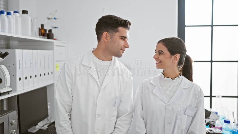 Two Scientists, a Man and a Woman, Smile at Each Other in a Bright ...