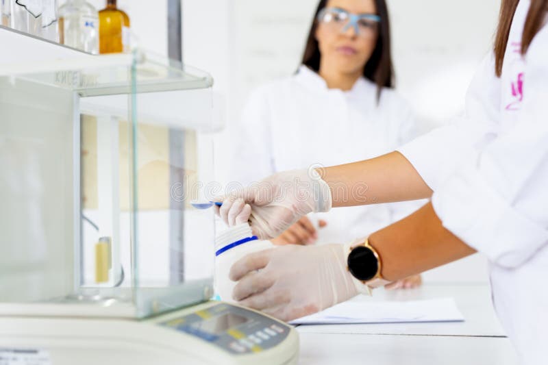 Two Scientists in White Lab Coats and Gloves are Working with Precision ...