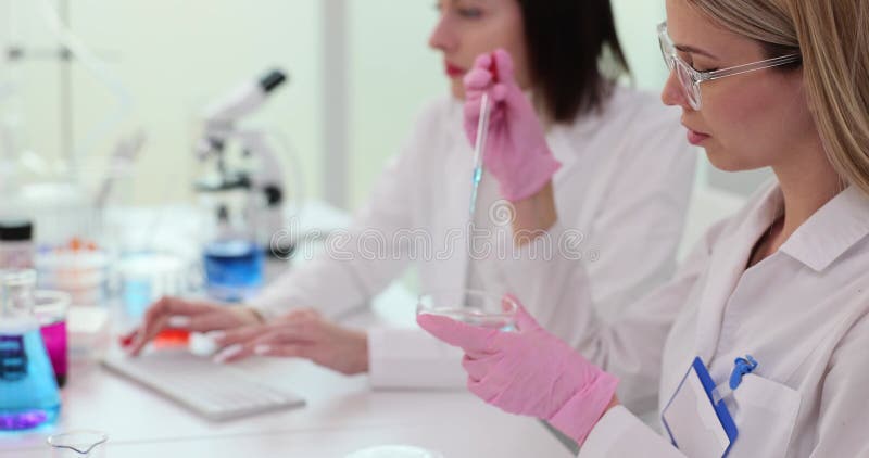 Two Scientists Working in a Laboratory and Blue Liquid Dripping Stock ...