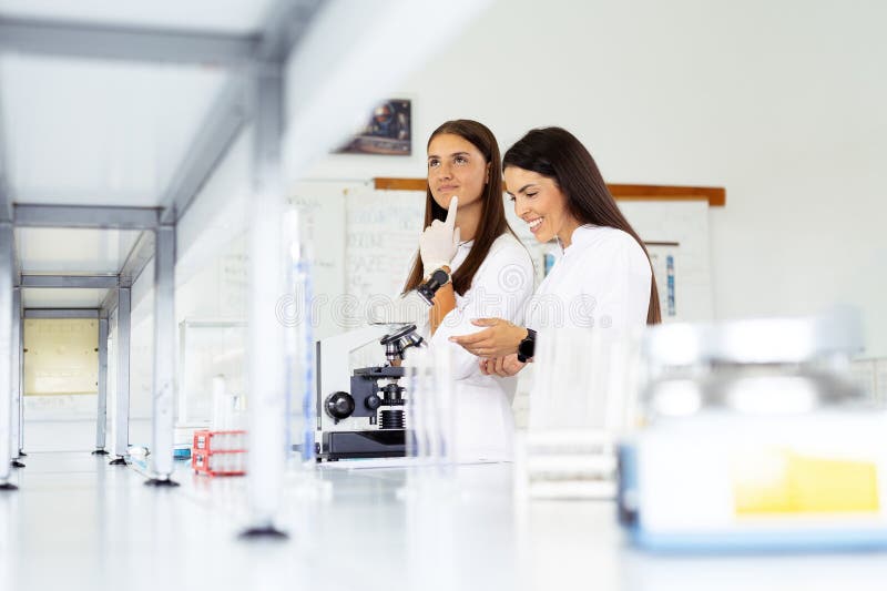 Two Scientists Working with a Microscope in a Lab Stock Photo - Image ...