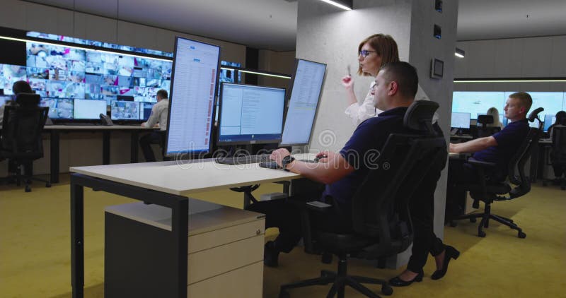 Two Security Guards Monitoring Modern CCTV Cameras in Surveillance Room ...