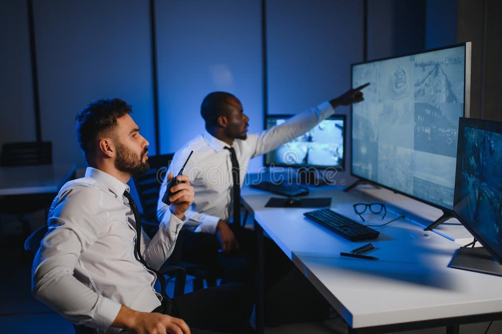 Two Security Guards Sitting by Workplace in Front of Monitors and ...