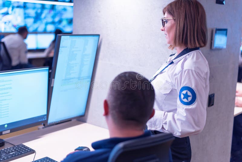 Two Security Guards Working on Computers while Sitting in the Main ...