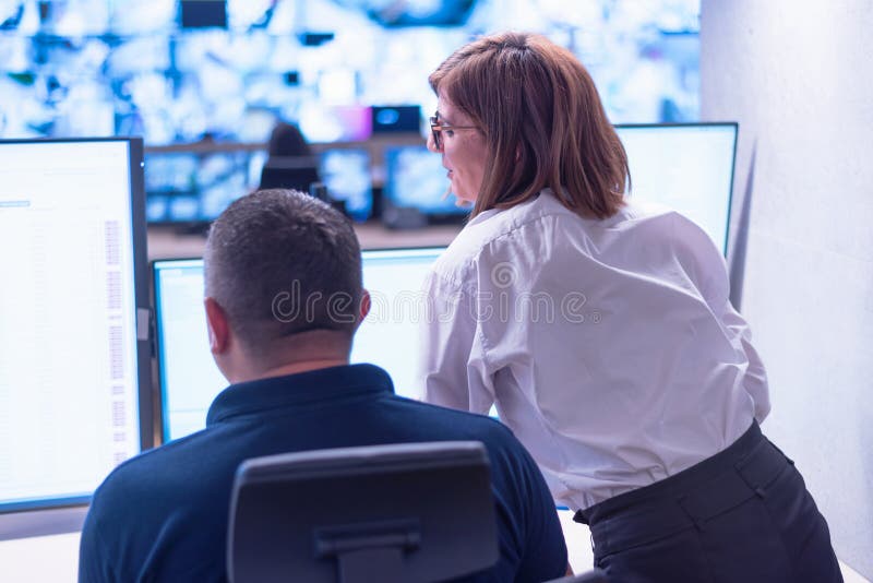 Two Security Guards Working on Computers while Sitting in the Main ...
