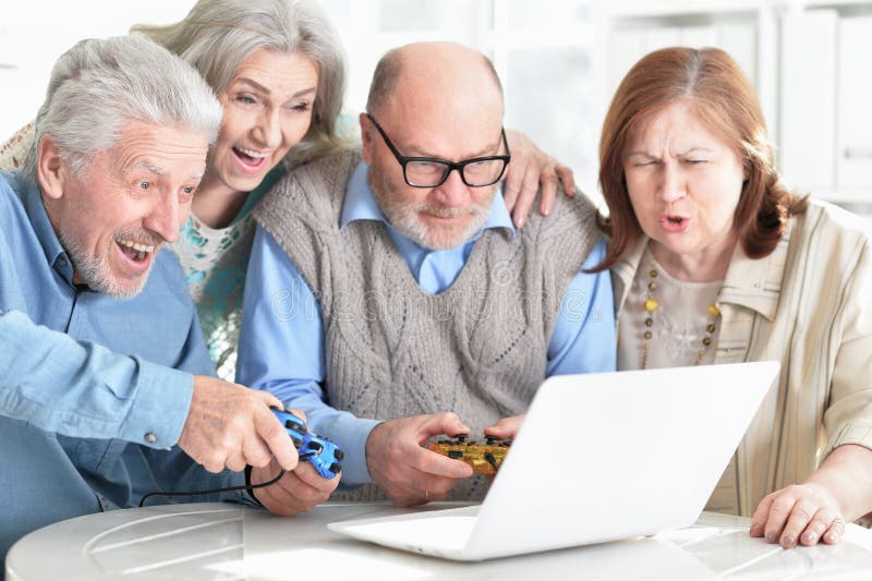 Two Senior Couples Sitting at Table and Playing Computer Stock Photo ...