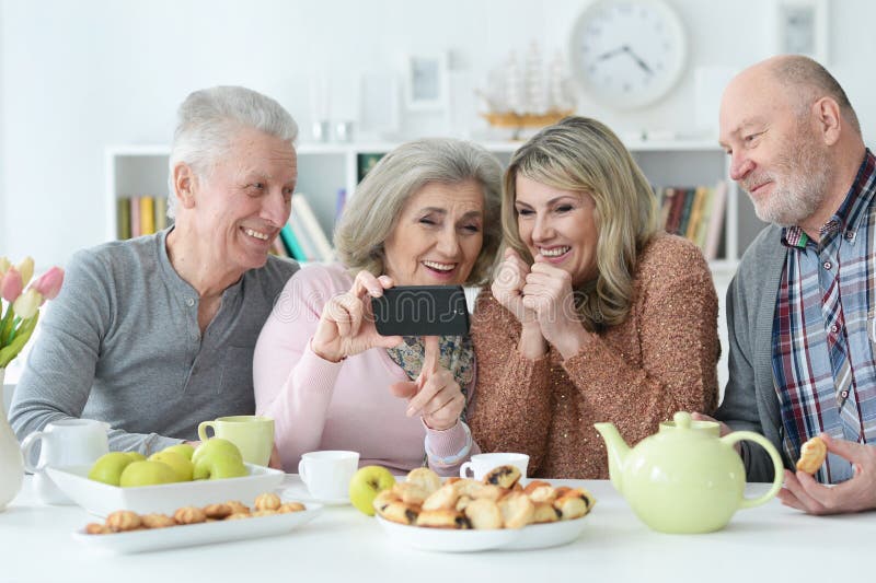 Two Senior Couples Using Smartphone during Morning Tea Stock Photo ...