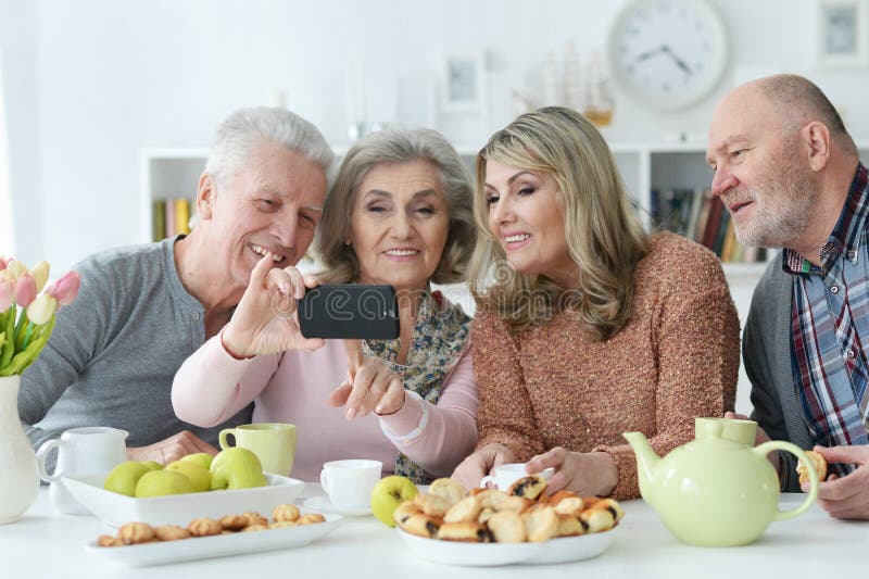 Two Senior Couples Using Smartphone during Morning Tea Stock Photo ...