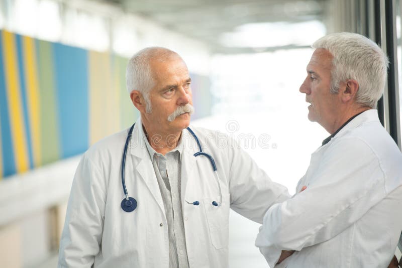 Two Doctors Talking To Each Other in Corridor Stock Image - Image of ...