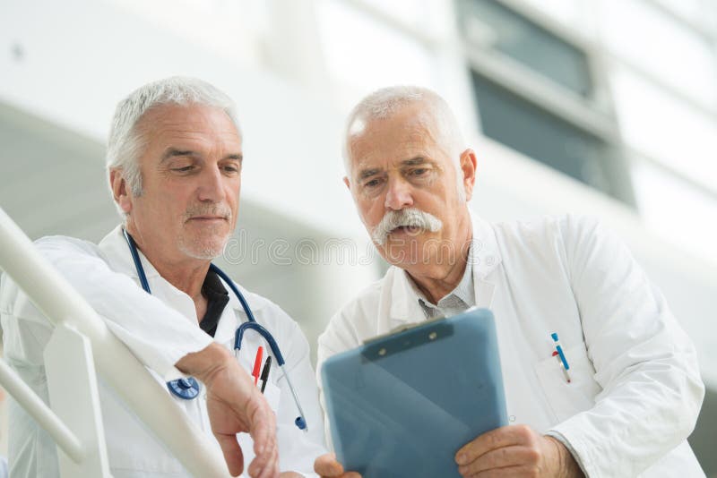 Two Senior Doctors Talking Together Stock Photo - Image of talking ...