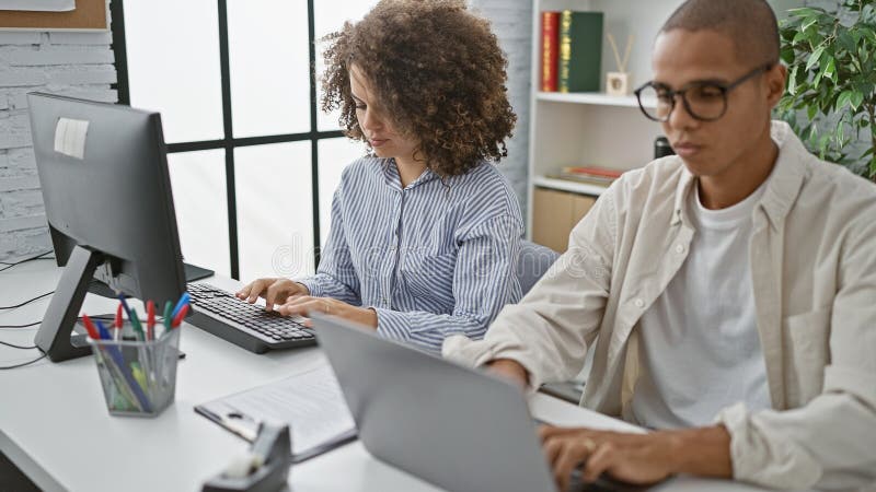 Two Serious-faced Workers, a Man and Woman, Intensely Working Together ...
