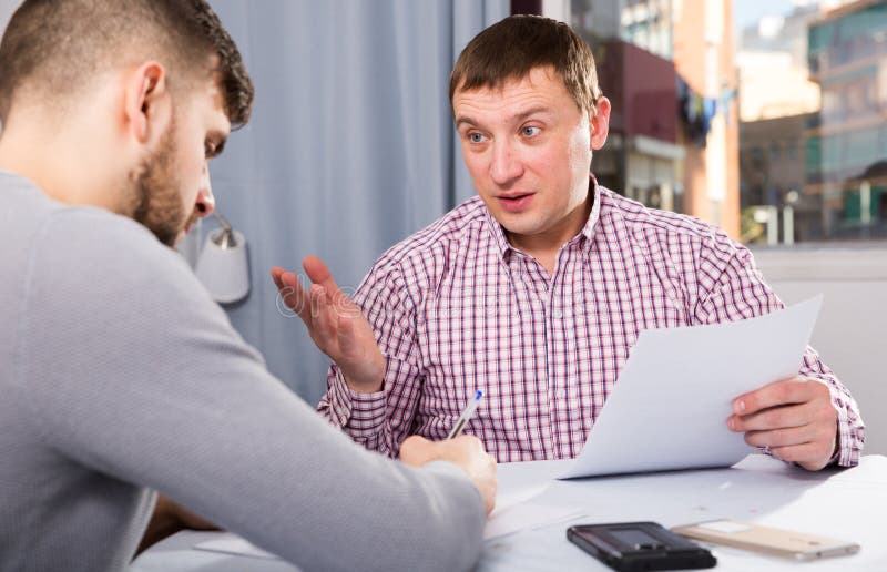 Two Serious Men Analysing Documents at Table Stock Image - Image of ...