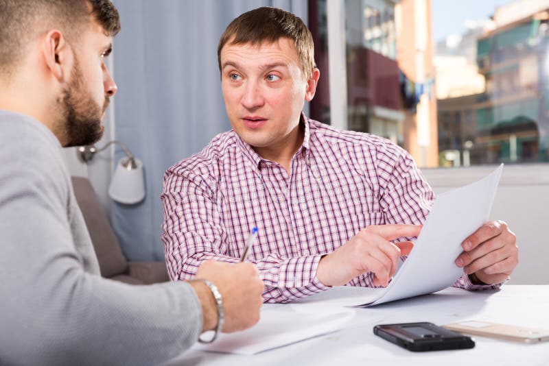 Two Serious Men Analysing Documents at Table Stock Photo - Image of ...