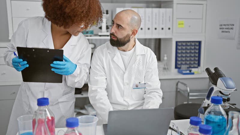 Two Serious Scientists at the Lab, High-tech Laptop and Clipboard in ...