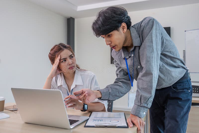 Two Serious and Stressed Asian Office Workers are Focusing on Their Co ...
