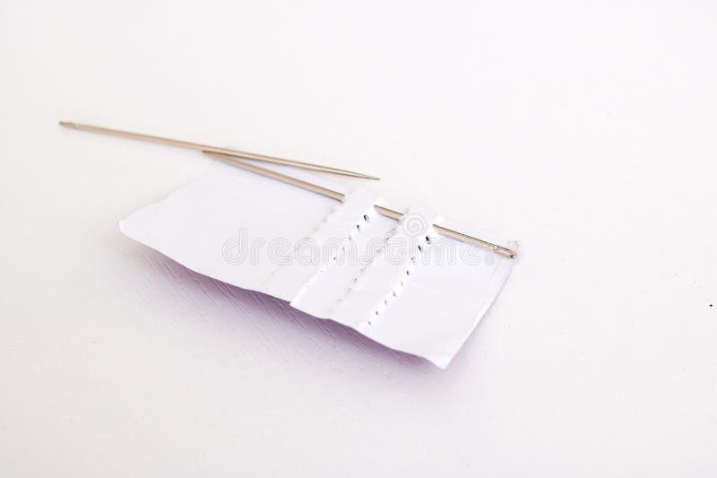 Two Sewing Needles Placed on Top of a Sheet of Paper Stock Photo ...