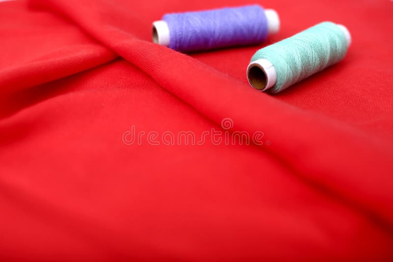 Two Sewing Thread on the Red Cloth Stock Photo - Image of colored ...