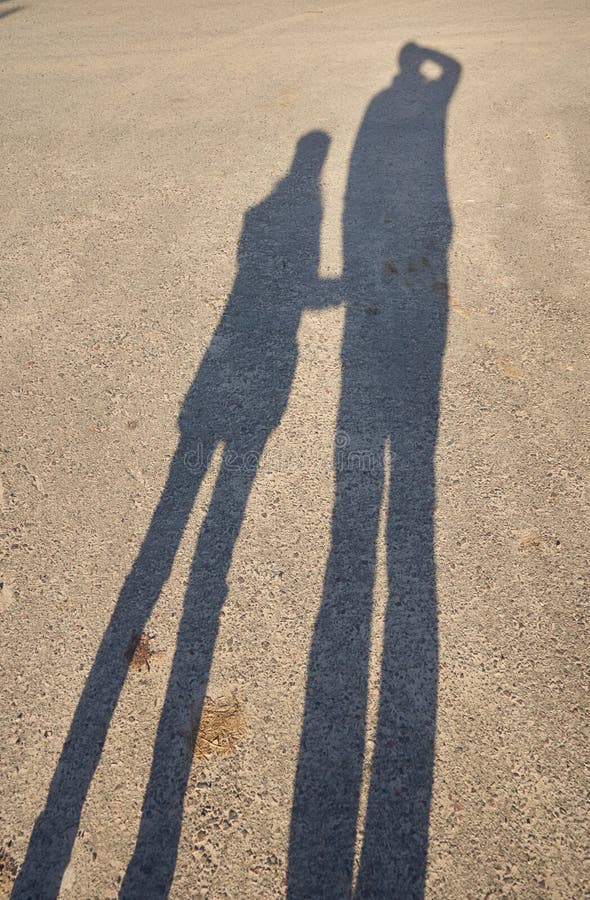 Two Shadows of People, the Shadow of a Man with a Child on the Asphalt ...