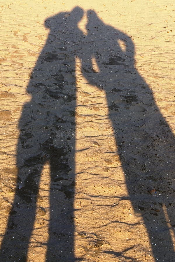Two Shadows Silhouette on the Sand at the Beach during Sunset. Shadow ...