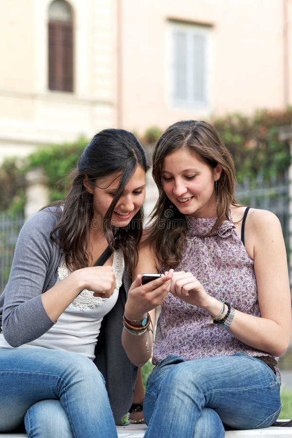 Two Shopping Girls in Park with a Mobile Phone Stock Photo - Image of ...