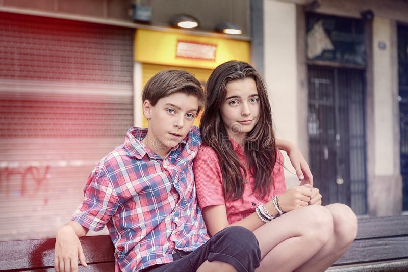 Two Siblings Crouching on a Bench Stock Photo - Image of checked ...