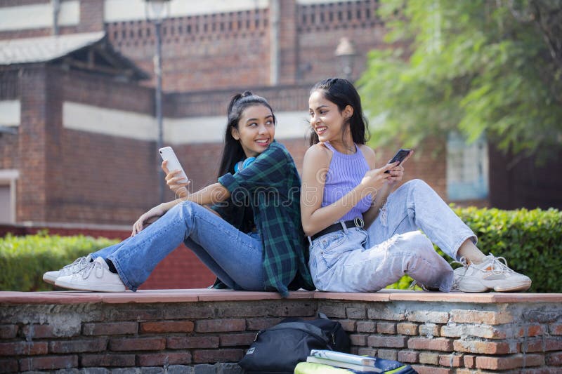 Two Siblings are Looking at Each Other while Holding Phones in Their ...