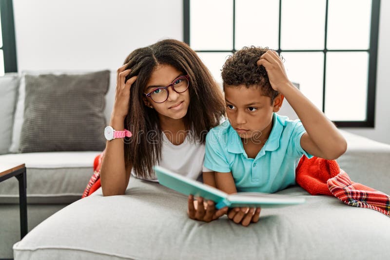 Two Siblings Lying on the Sofa Reading a Book Confuse and Wondering ...