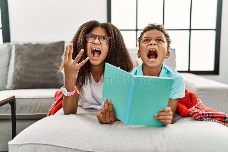 Two Siblings Lying on the Sofa Reading a Book Crazy and Mad Shouting ...
