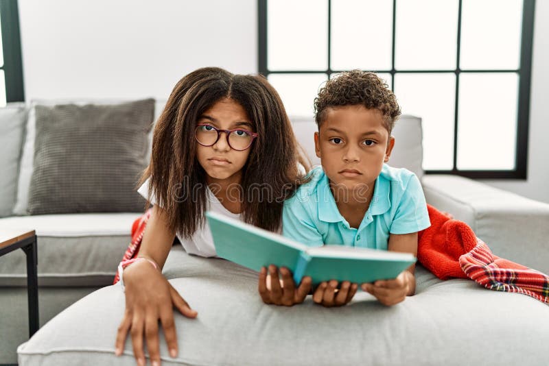 Two Siblings Lying on the Sofa Reading a Book Depressed and Worry for ...