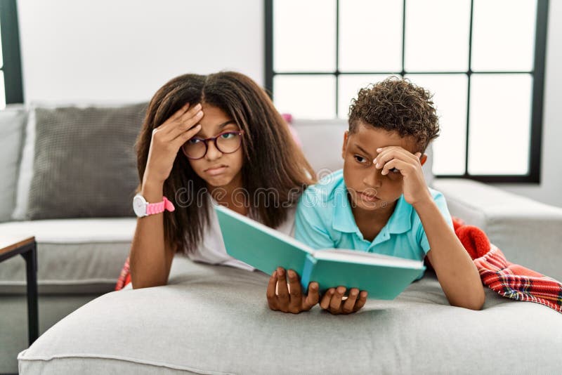Two Siblings Lying on the Sofa Reading a Book Worried and Stressed ...