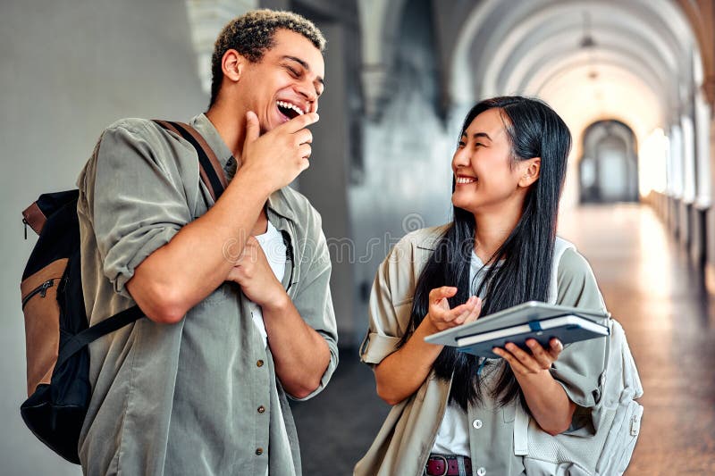 Two Sincere Students are Talking and Laughing while Standing in a ...