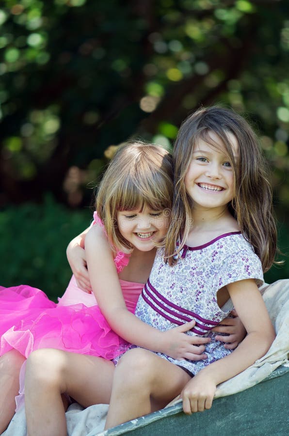 Two sisters stock image. Image of childhood, garden, ride - 24427785
