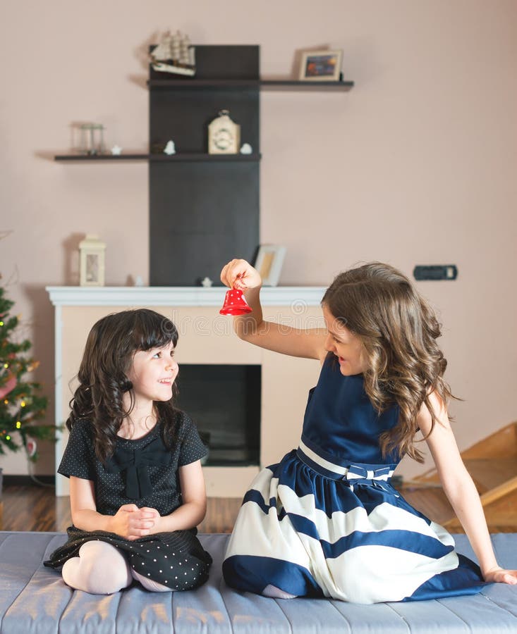 Two Sisters Amusing Themselves with a Bell at Christmas Stock Photo ...