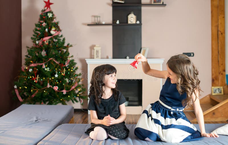 Two Sisters Amusing Themselves with a Bell at Christmas Stock Photo ...