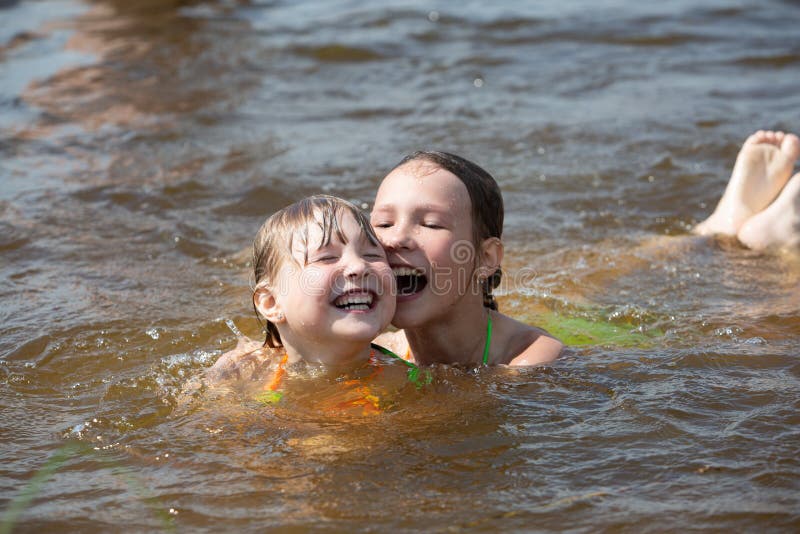 Two Sisters Have Fun Playing, Swimming In A Warm River In The Summer ... Two Sisters Have Fun Playing, Swimming In A Warm River In The Summer ...