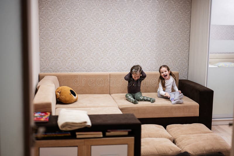 Two Sisters at Home on the Sofa Laughing Loudly Together Stock Image ...