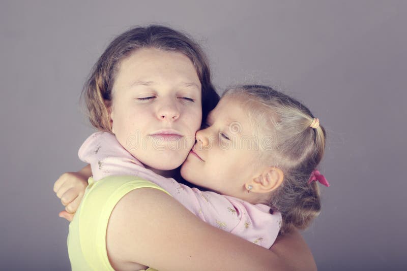 Two sisters hug each other stock photo. Image of cuddle - 138806856