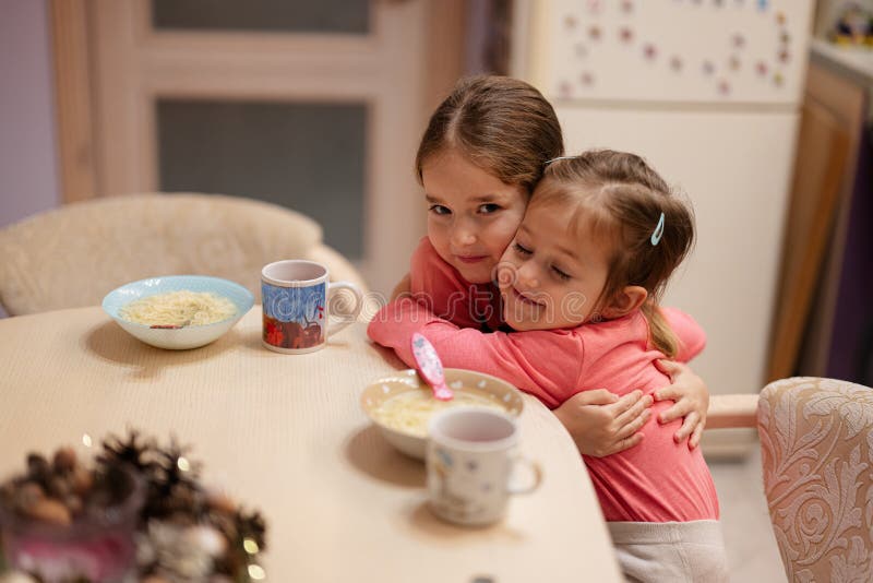 Two Sisters Hugs and Have Dinner Together in the Kitchen Stock Image ...