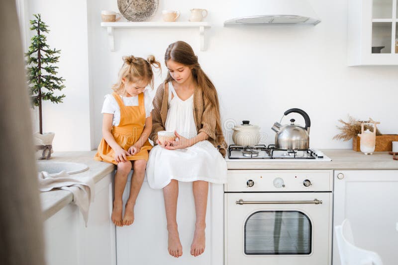 Two Sisters Play in a Bright, Stylish Kitchen. Beautiful Interior Stock ...