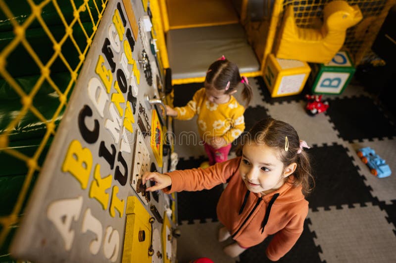 Two Sisters Playing with Busy Board at Kids Play Center Stock Photo ...