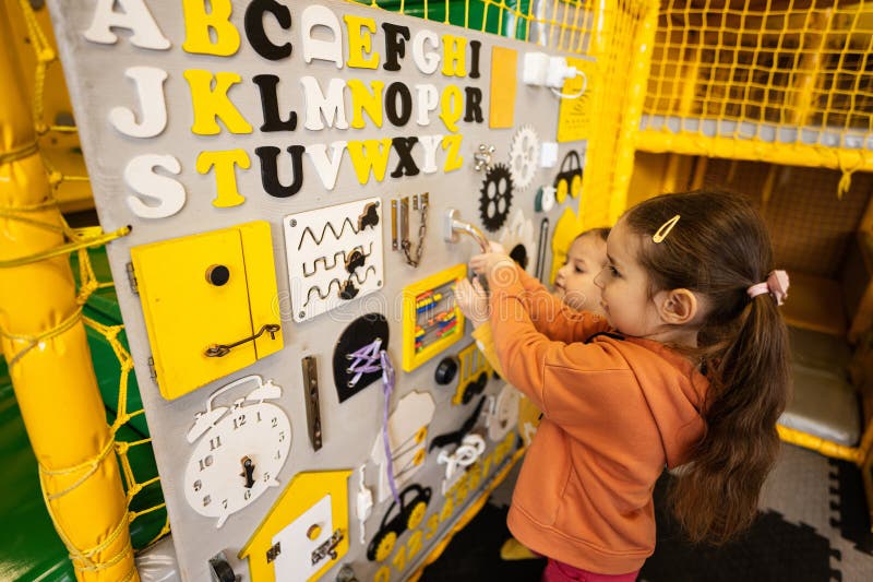 Two Sisters Playing with Busy Board at Kids Play Center Stock Image ...