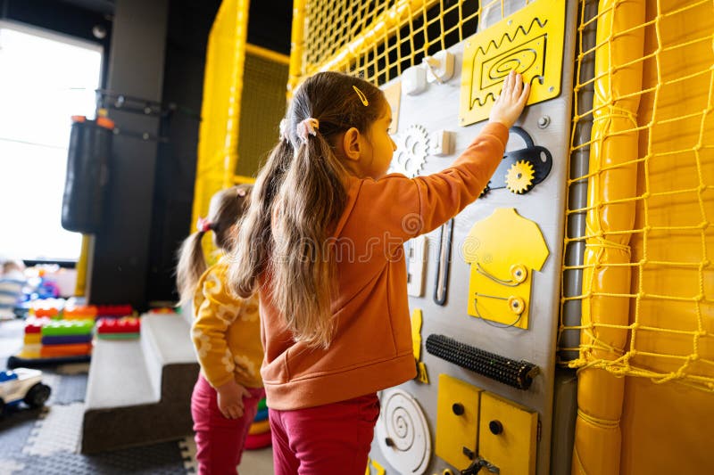 Two Sisters Playing with Busy Board at Kids Play Center Stock Photo ...