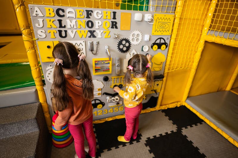 Two Sisters Playing with Busy Board at Kids Play Center Stock Photo ...