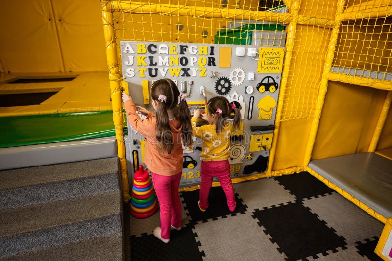 Two Sisters Playing with Busy Board at Kids Play Center Stock Image ...