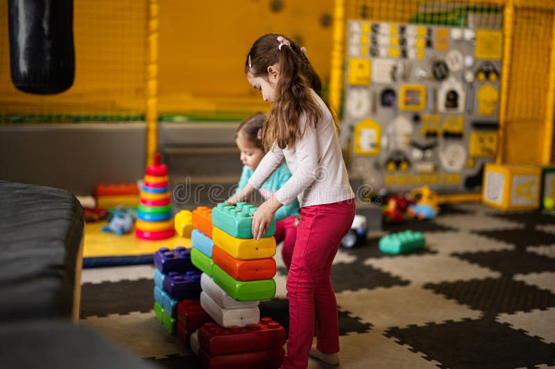 Two Sisters Playing at Kids Play Center while Build with Colored ...