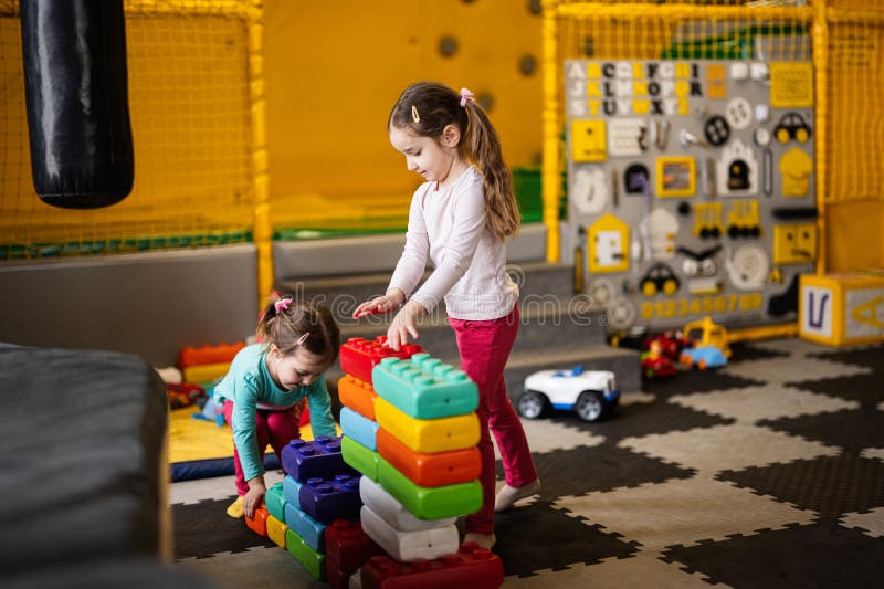 Two Sisters Playing at Kids Play Center while Build with Colored ...