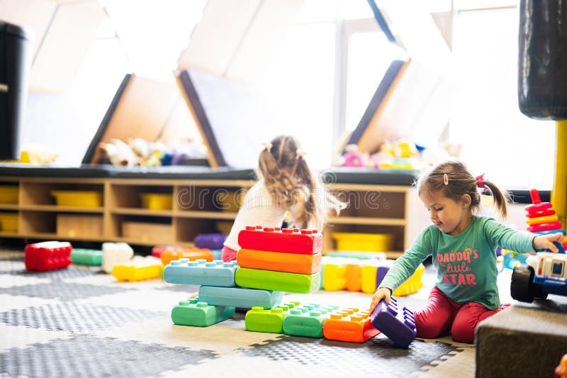 Two Sisters Playing at Kids Play Center while Build with Colored ...
