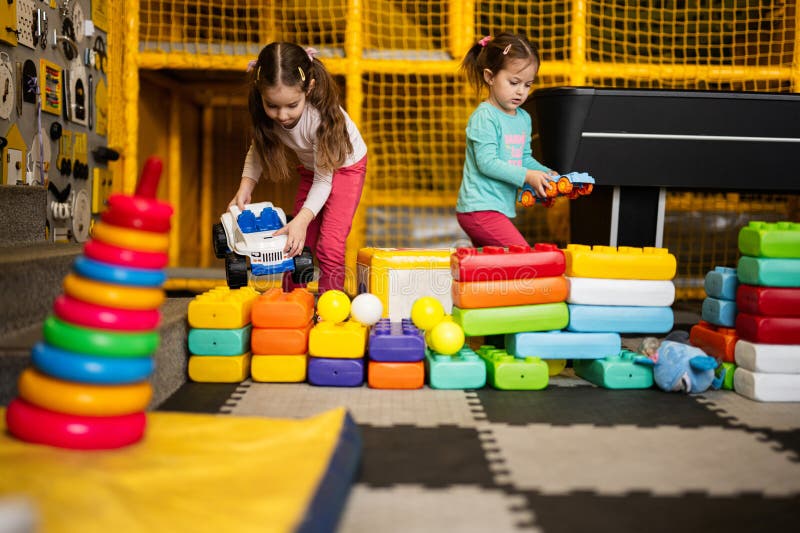 Two Sisters Playing at Kids Play Center while Build with Colored ...