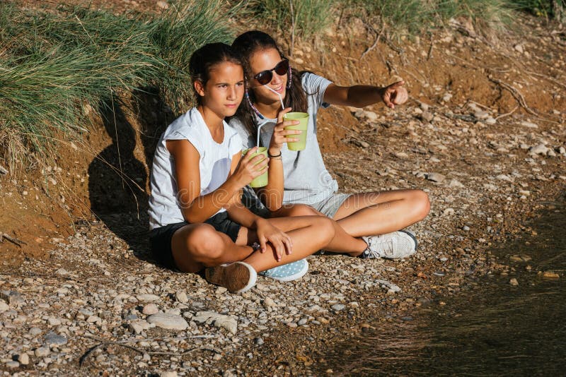 Two Sisters Sitting by the Lake Contemplating the Landscape Stock Image ...