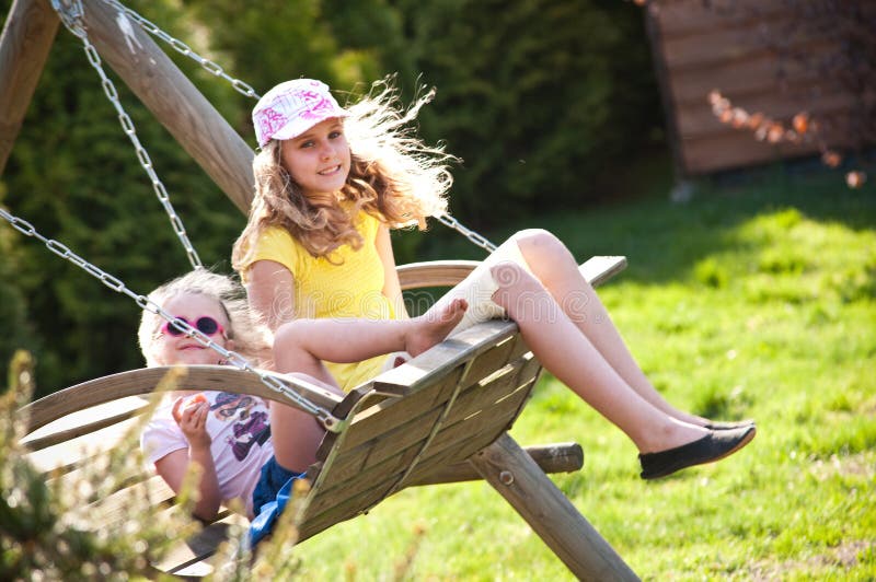 Two sisters on swing stock photo. Image of grass, summer - 24741790