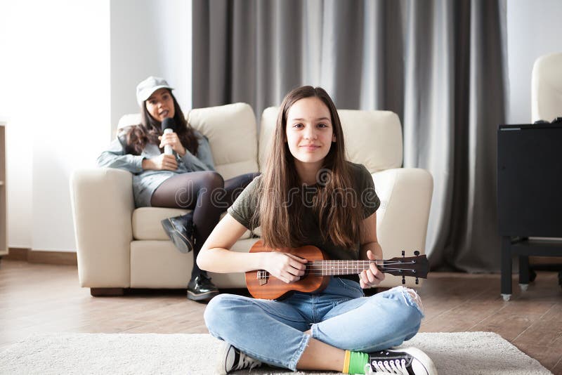 Two Sisters, the Younger One is Playing a Small Guitar in Front at the ...